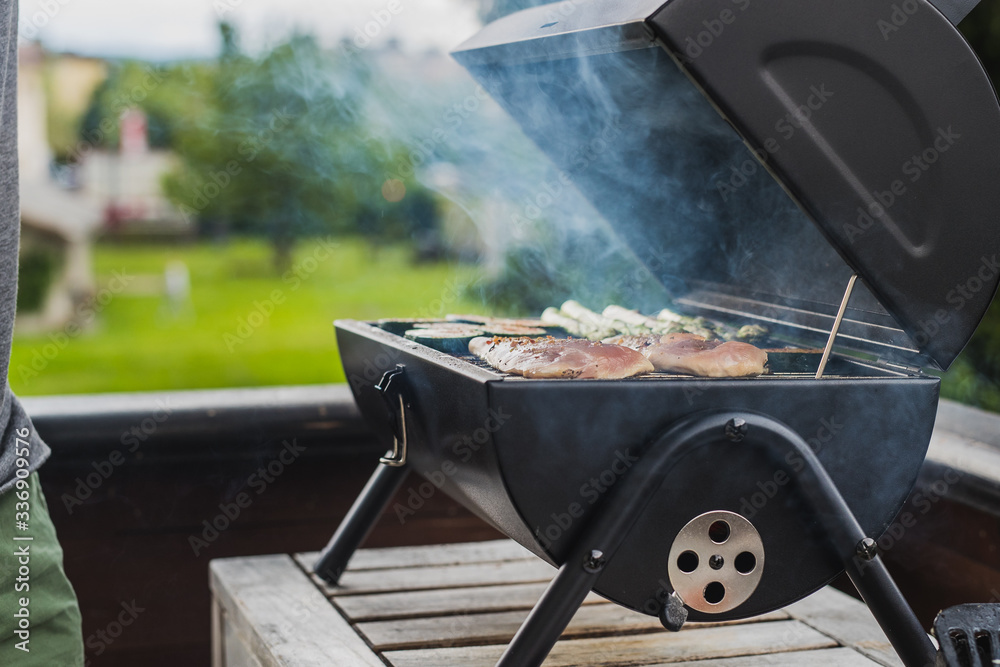Smoke coming out of a smokestack of a small black smoker grill or ...