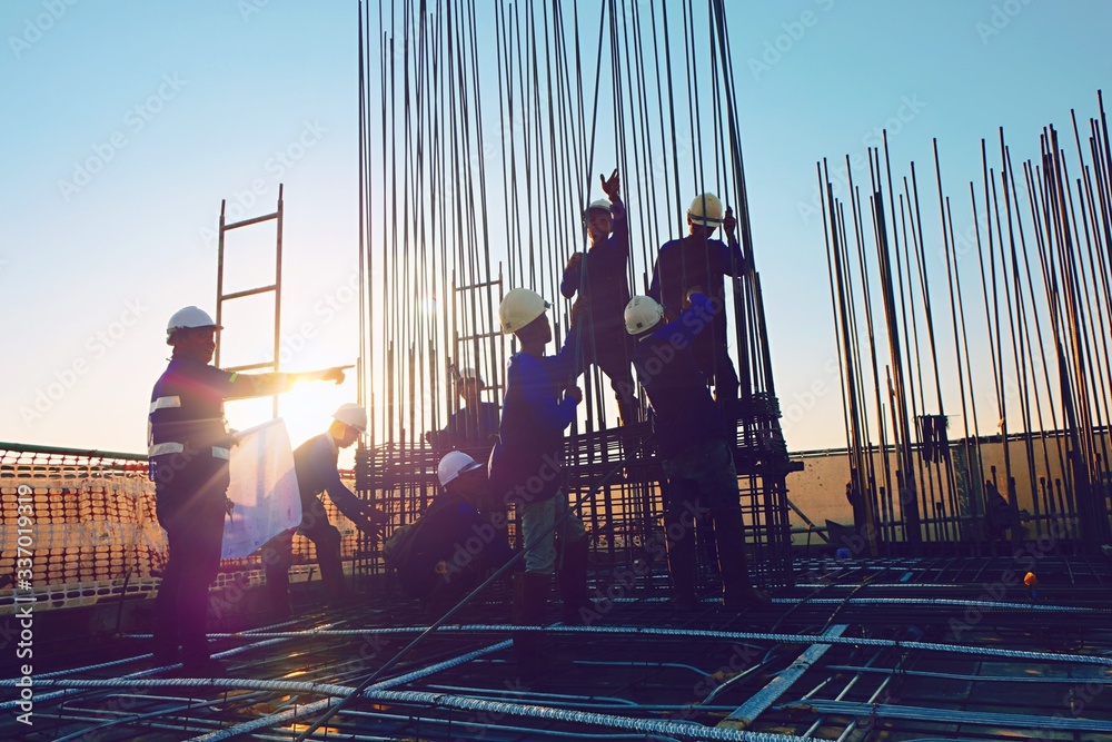 The construction of a rooftop high rise building, workers are tied with ...
