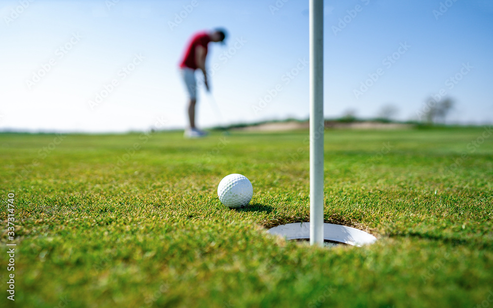 Golfer putting golf ball on the green golf. One of golf players going ...