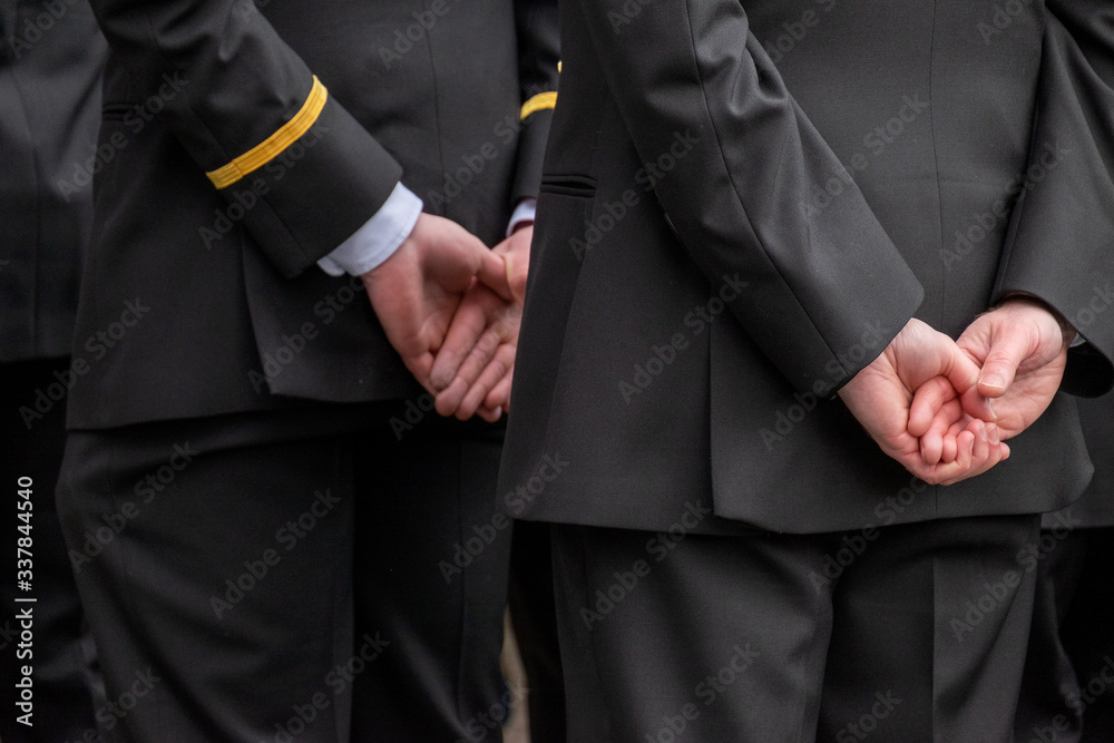 Military officers standing at a parade at ease with their hands behind ...