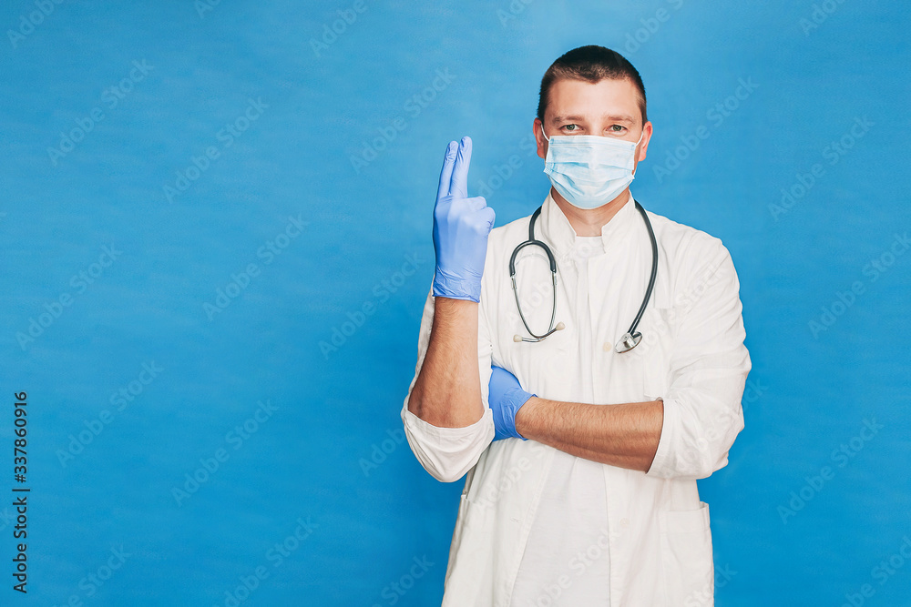 Doctor proctologist on a blue background in a white coat, gloves and a ...