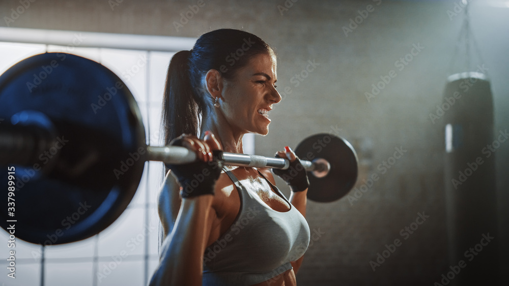 Athletic Beautiful Woman Does Overhead Lift with a Barbell in the Gym ...