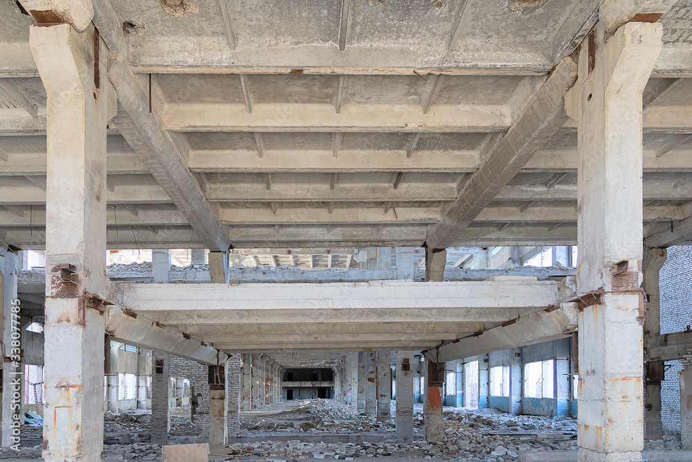 Destroyed reinforced concrete industrial building. View inside. Columns ...