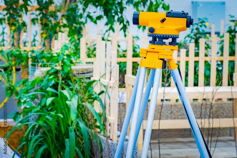 Theodolite on the background of the front garden. Optical level ...