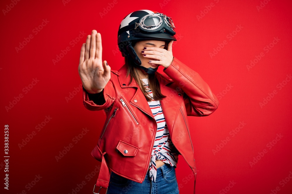 Young beautiful brunette motocyclist woman wearing motorcycle helmet ...