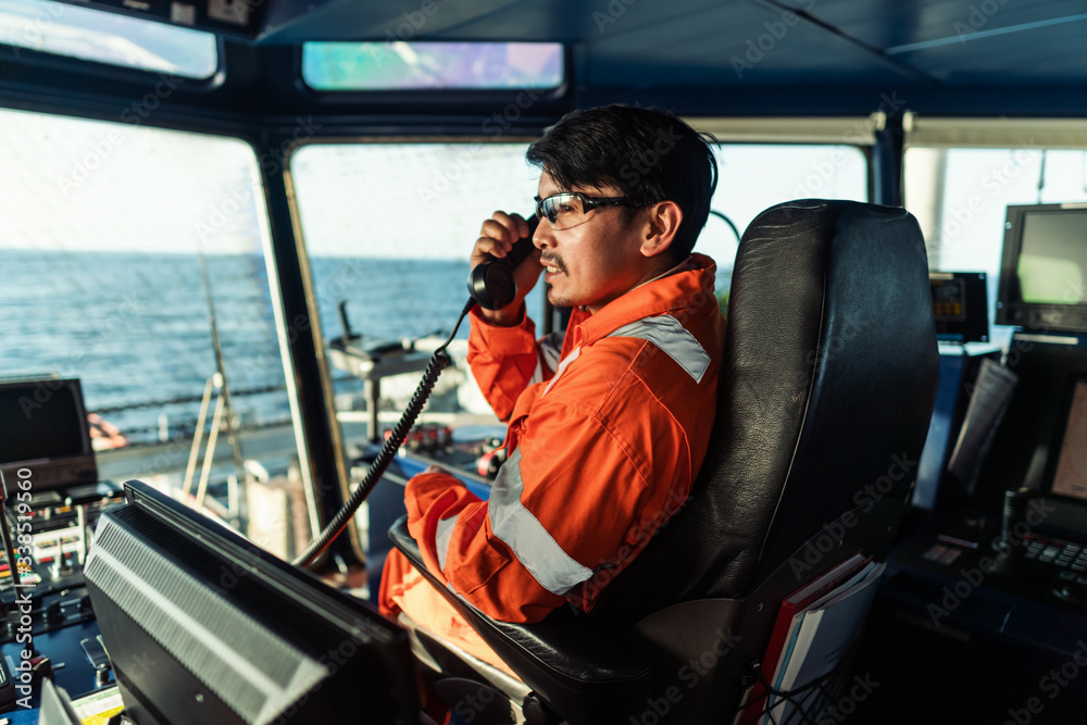 Filipino deck Officer on bridge of vessel or ship wearing coverall ...