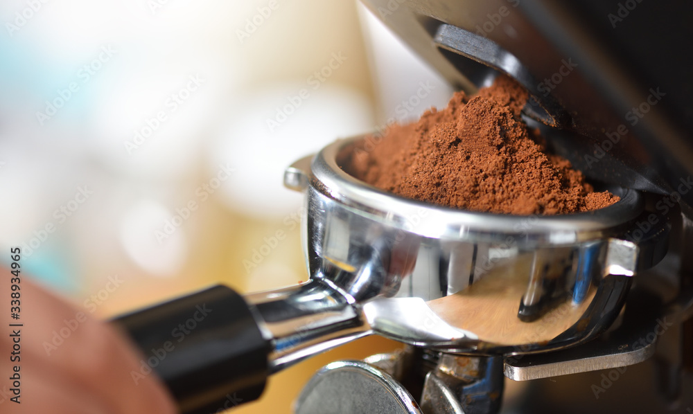 Freshly ground coffee in a port filter horn for a coffee machine. Close ...