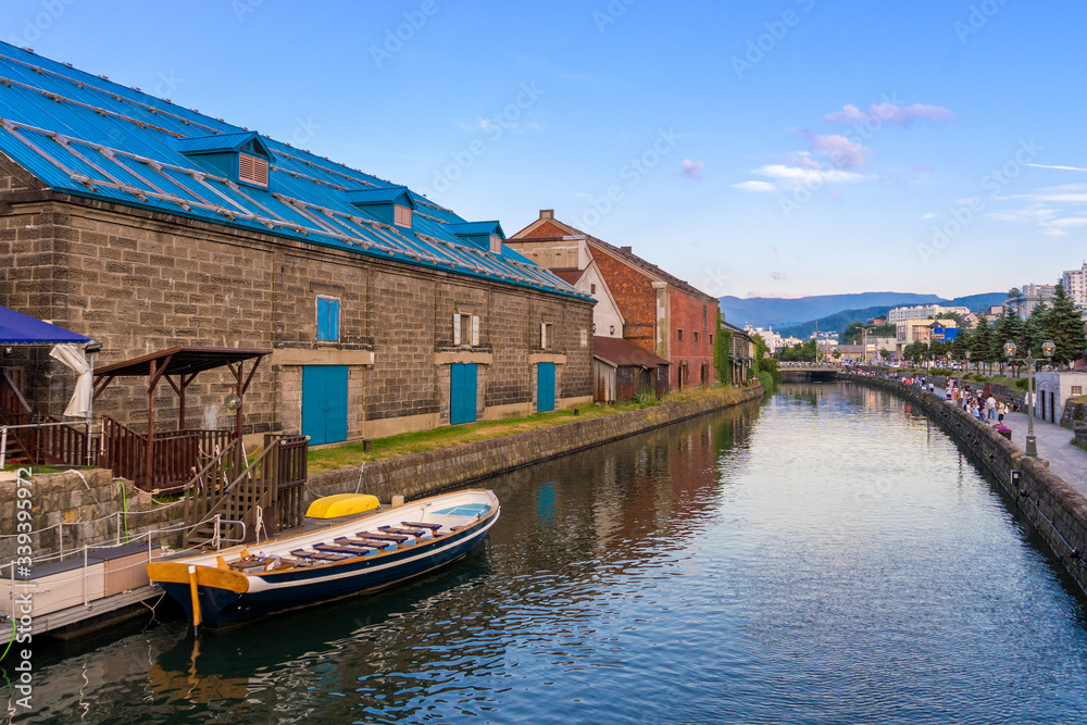 View of Otaru canal with tourist boat and blue sky in Summer in Otaru ...