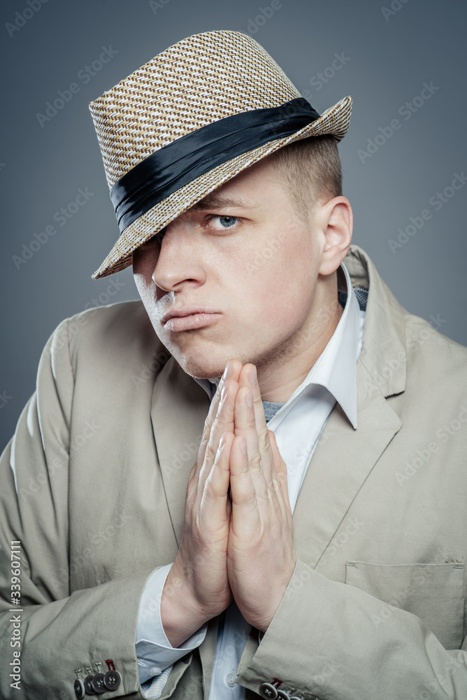 Closeup portrait desperate young man in hat showing clasped hands ...