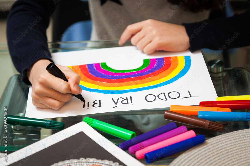 Girl's hands drawing rainbow picture in times of coronavirus with the ...