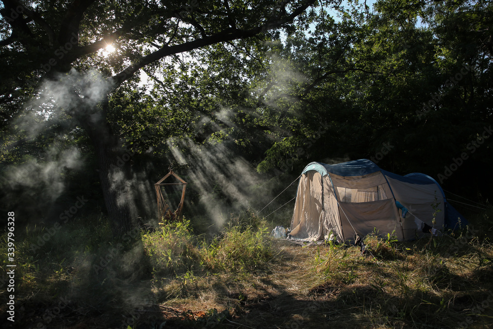 rays of light shine on the tent through the smoke from the fire Stock ...