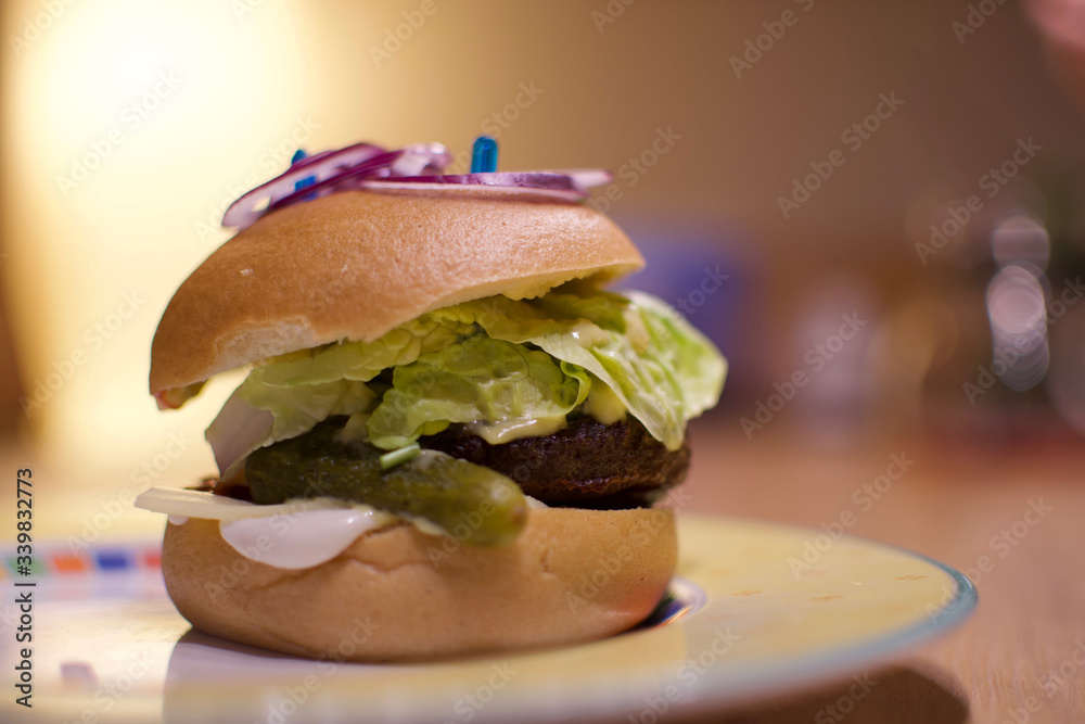 ein frisch zubereiteter burger mit zwiebeln gurke salat und rindfleisch ...