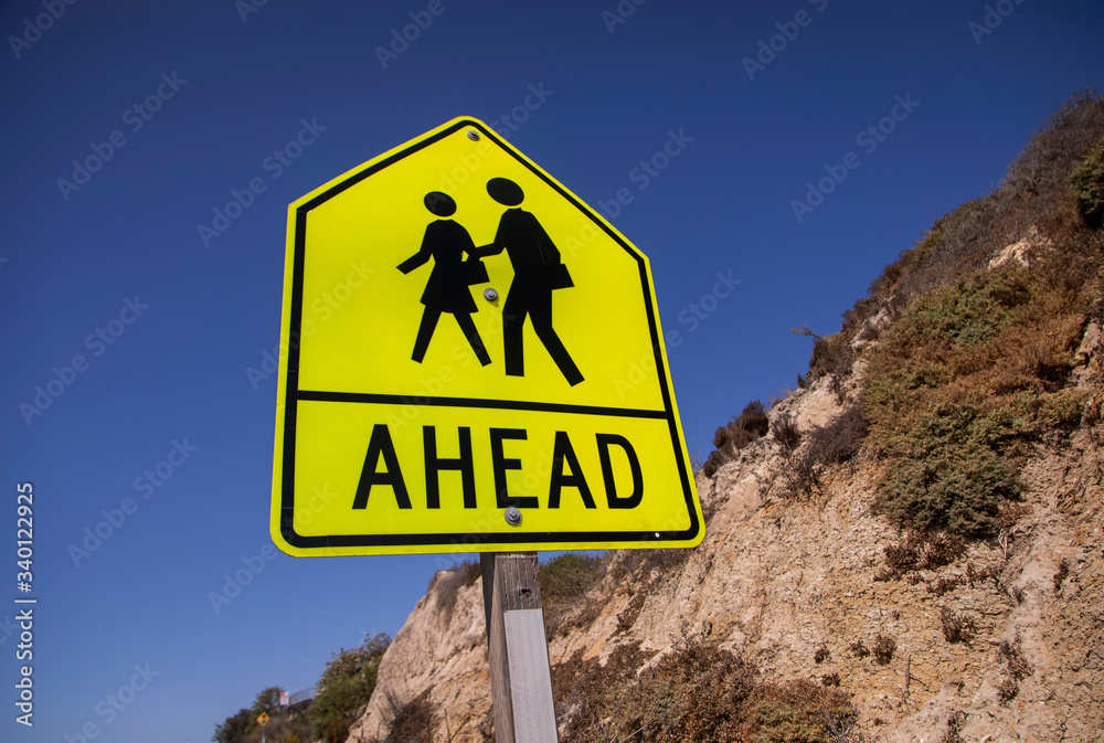 Bright yellow school crossing traffic sign with graphic of boy and girl ...