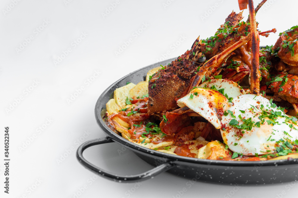 Formentera Lobster with fried potatoes, eggs and parsley in a ...