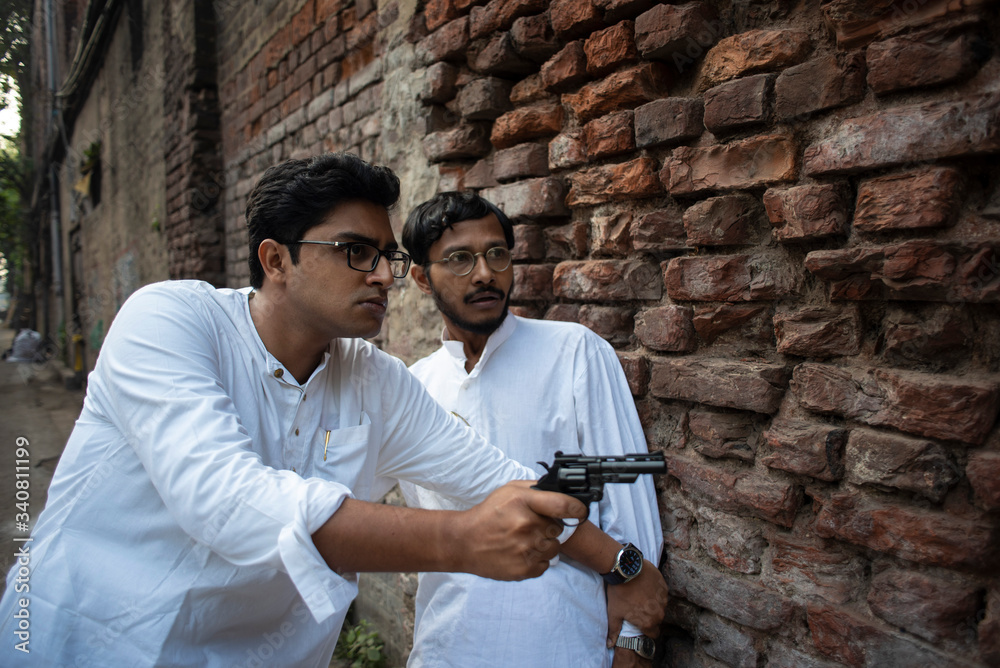 An young Indian Bengali detective and his assistant with traditional ...