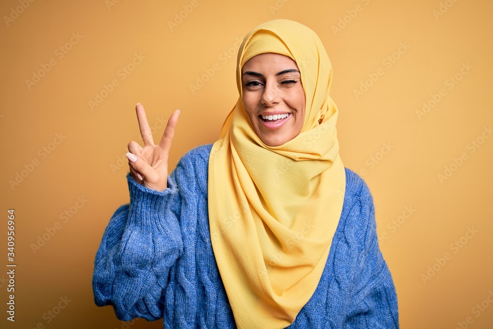 Young beautiful brunette muslim woman wearing arab hijab over isolated ...