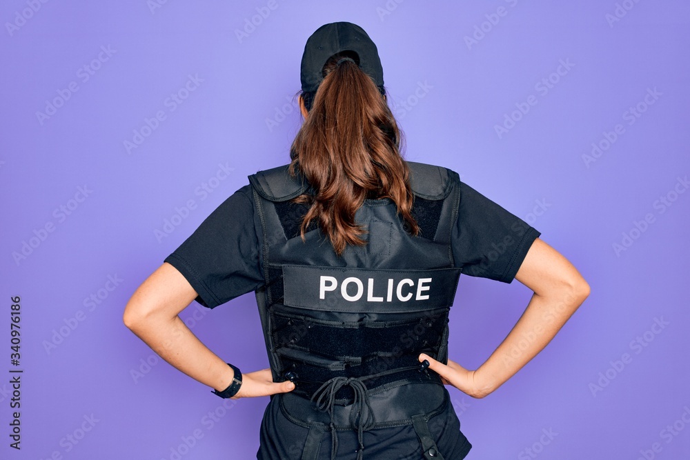 Young police woman wearing security bulletproof vest uniform over ...