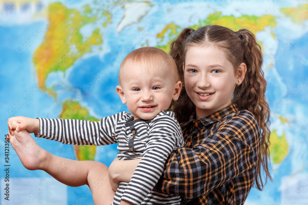Beautiful teenage girl hugs little brother with a typewriter in his ...