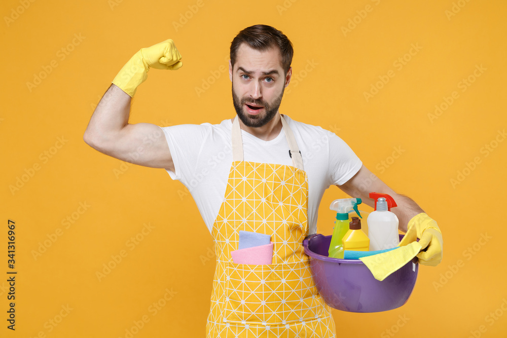 Strong man househusband in apron rubber gloves hold basin with ...
