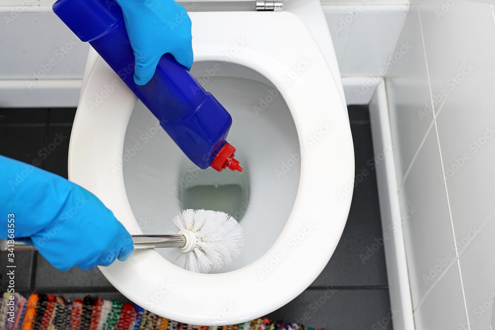 Toilet detergent disinfection. A woman cleans the toilet with a ...