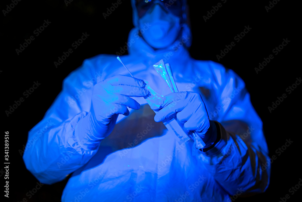 Doctor wearing protective clothing, holding viral swab test Stock Photo ...