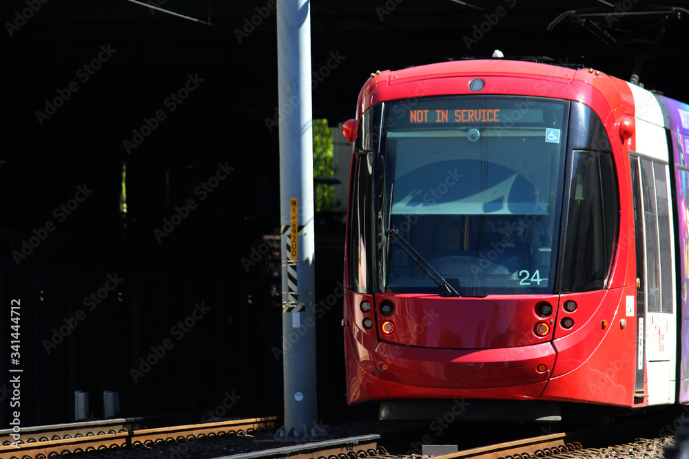 Foto de Stock Pictured is a red light rail train coming out of a tunnel ...