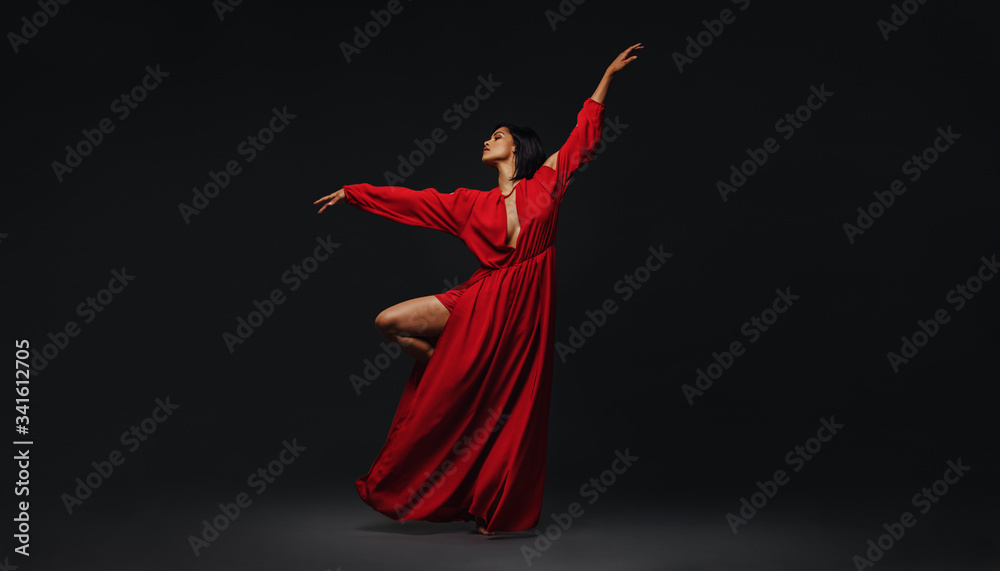 Woman dancing gracefully on black background の Stock フォト | Adobe Stock
