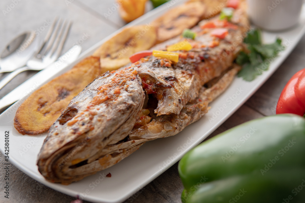 Grilled fish curry with plantain and salad. African national dish ...