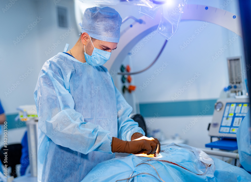 Spinal surgery. Group of surgeons in operating room with surgery ...