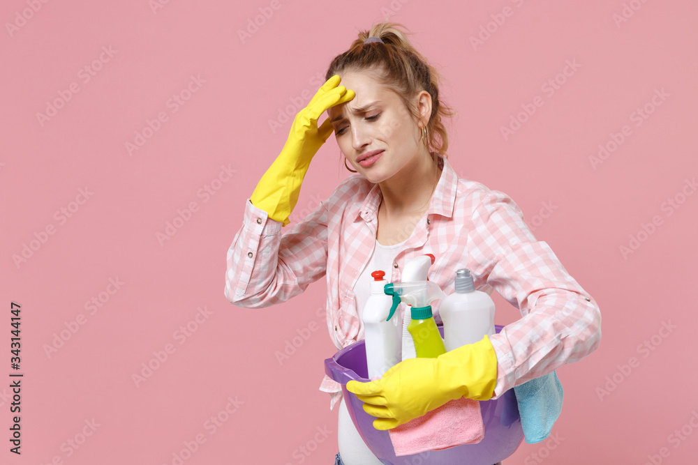 Upset tired young woman housewife in rubber gloves hold basin with ...