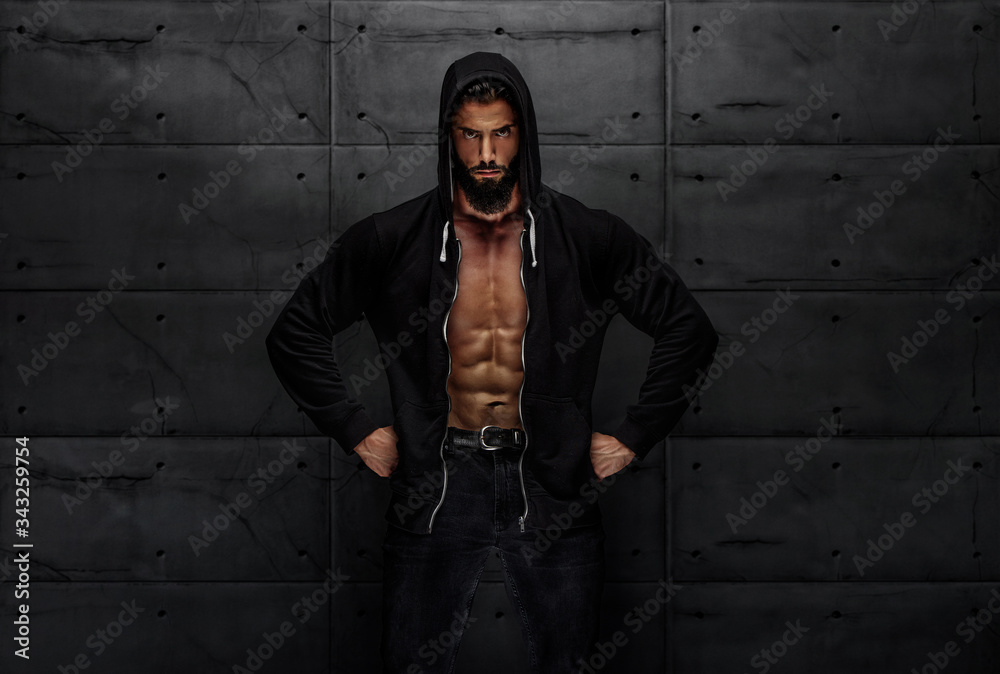 Handsome macho man posing shirtless in unbuttoned coat with hood ...