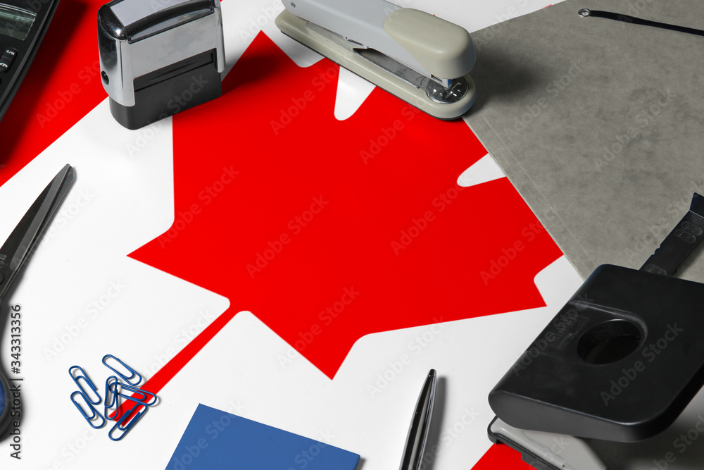 Canada flag with office clerk workplace background. National stationary ...