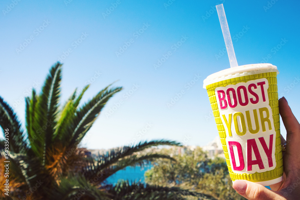 bright big plastic glass with words boost your day on the blue sky ...