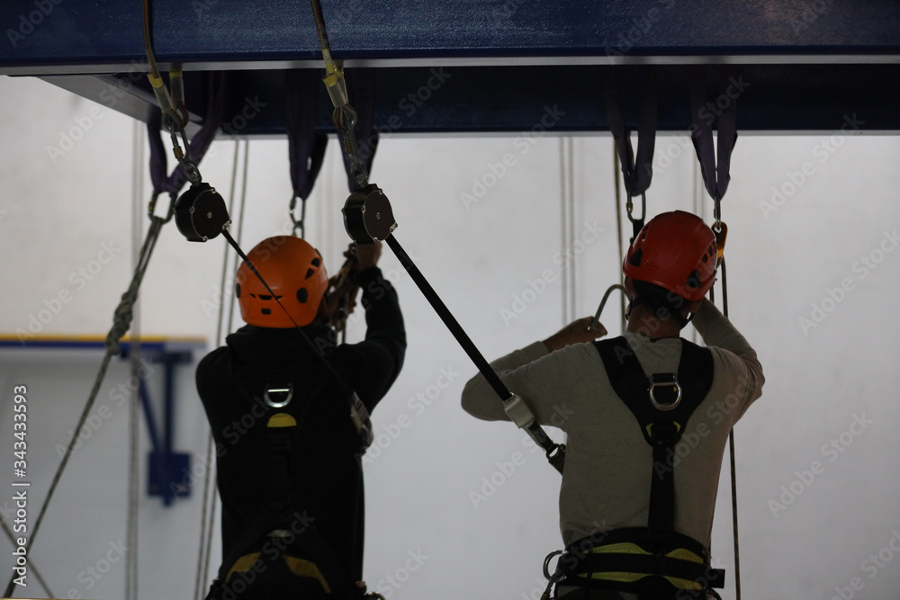 Abseiler maintenance wearing orange safety fall protection helmet ...