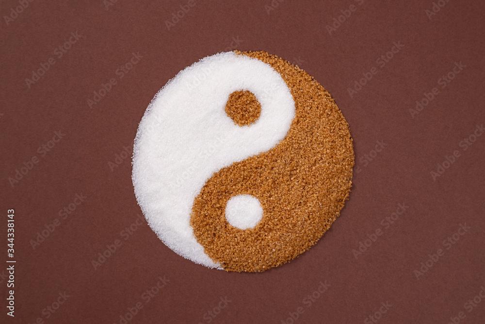 Yin yang symbol made with refined white sugar and cane sugar. Visual ...