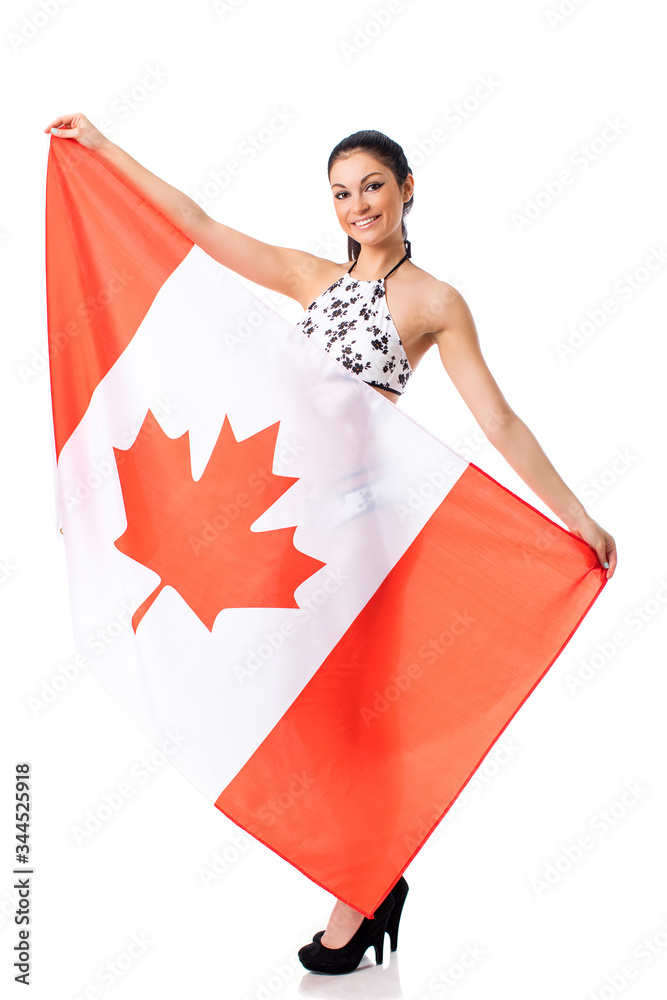 Young beautiful brunette woman in bikini holding a large Canadian flag ...
