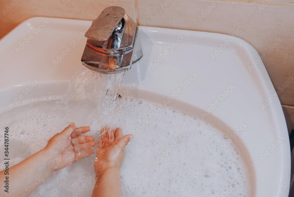 Cute little toddler girl washing her hands in a bathroom. Hygiene ...