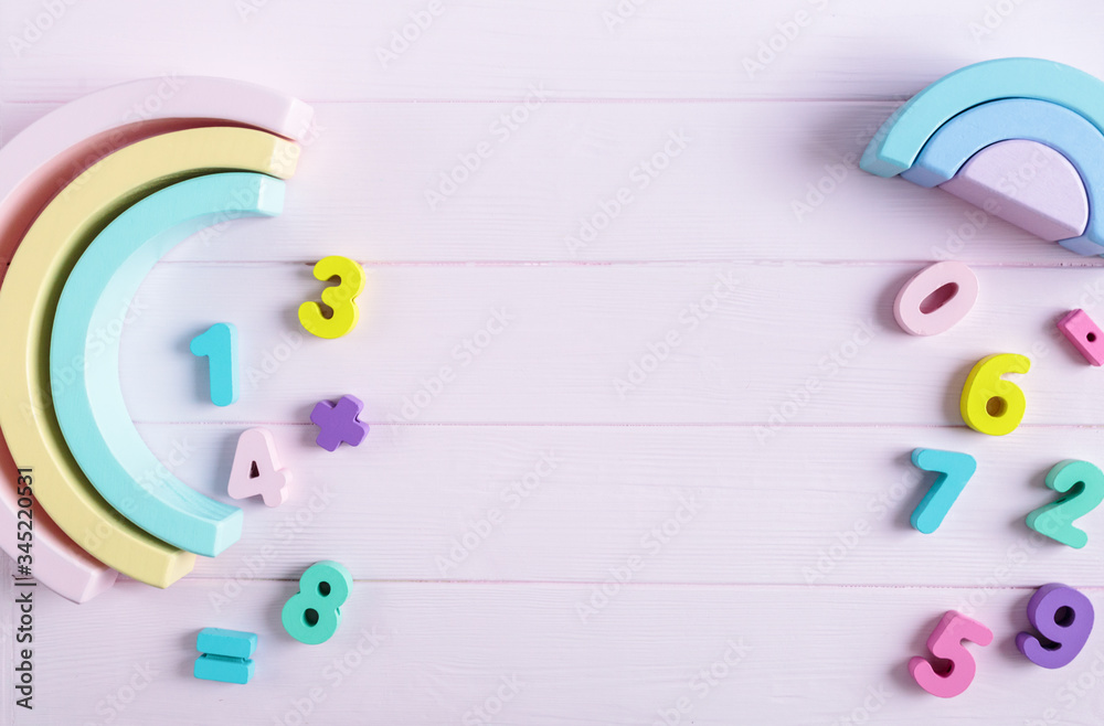 Wooden toy rainbow, numbers, blocks, pastel color arc on pink ...