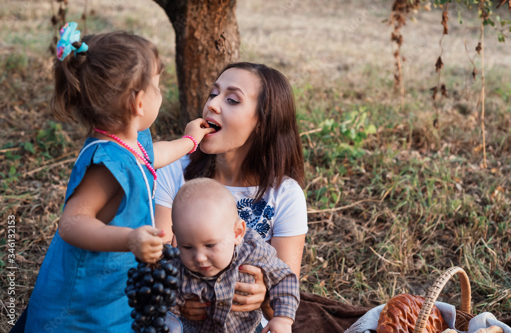 The girl feeds Mom delicious grapes. The baby puts her mother in her ...