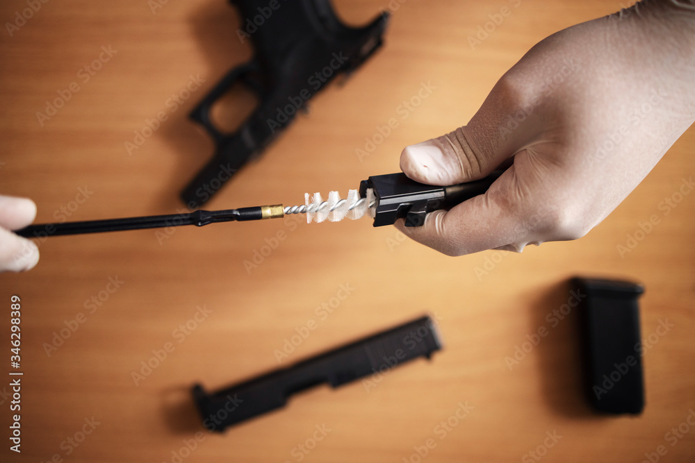 Cleaning gun barrel with brush tool. Firearm cleaning and maintenance ...