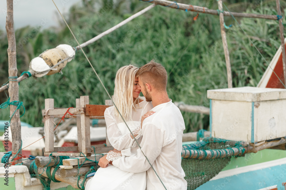 Happy Romantic honeymoon couple on the beach sitting on old fishing ...