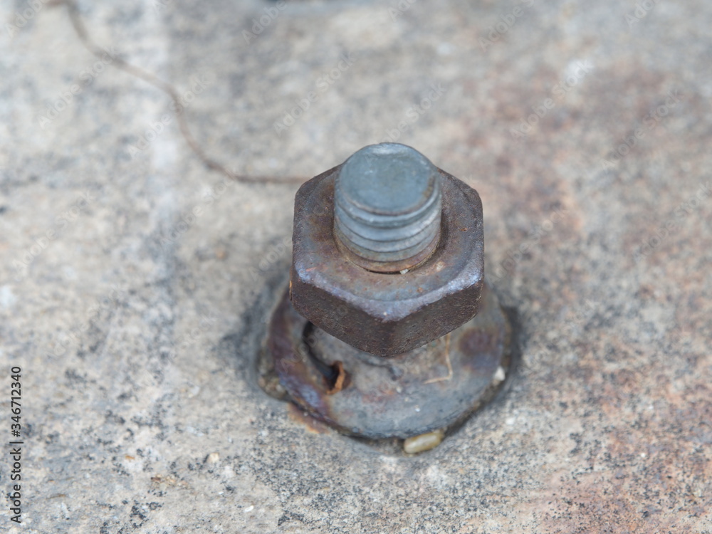 Old and rusty steel hex bolt and nut on the concrete wall. Attached ...