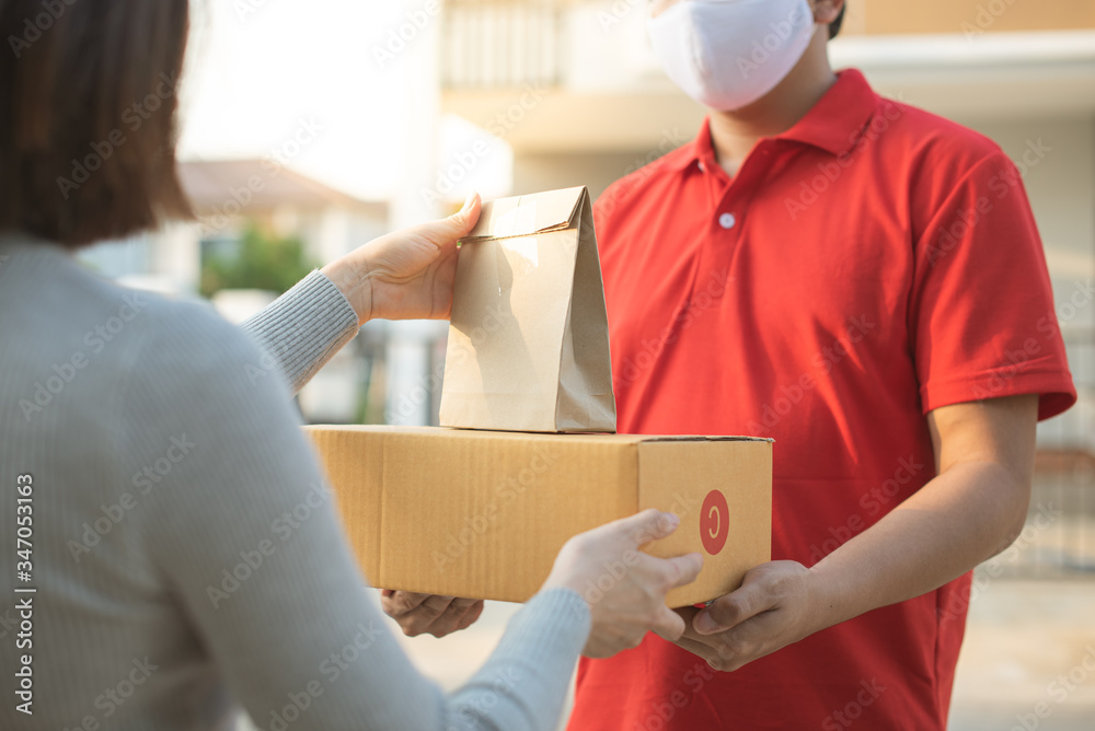 Deliver man wearing face mask in red uniform handling bag and parcel ...