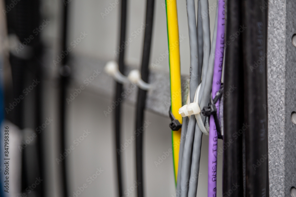 Cables fastened with white ties on the cable ladder. Black, gray ...