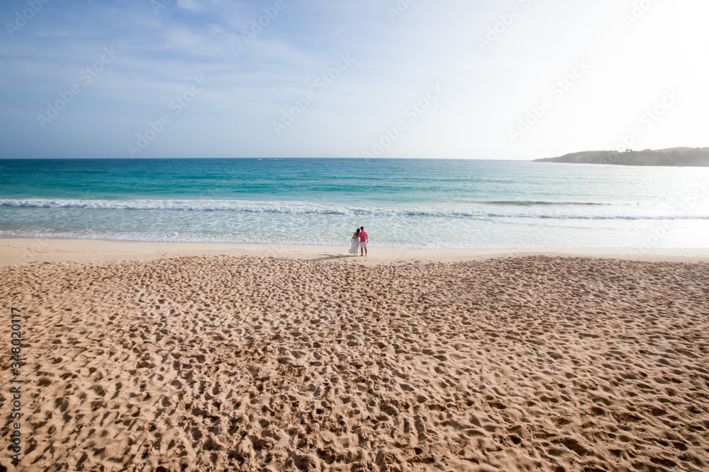 Romantic couple in love hugging, kissing and running on the sandy ...