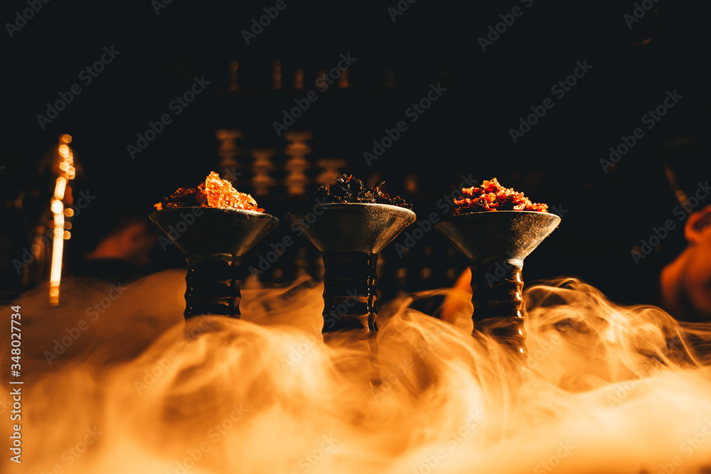 Side view of different kinds of hookah tobacco on smoky bar counter ...