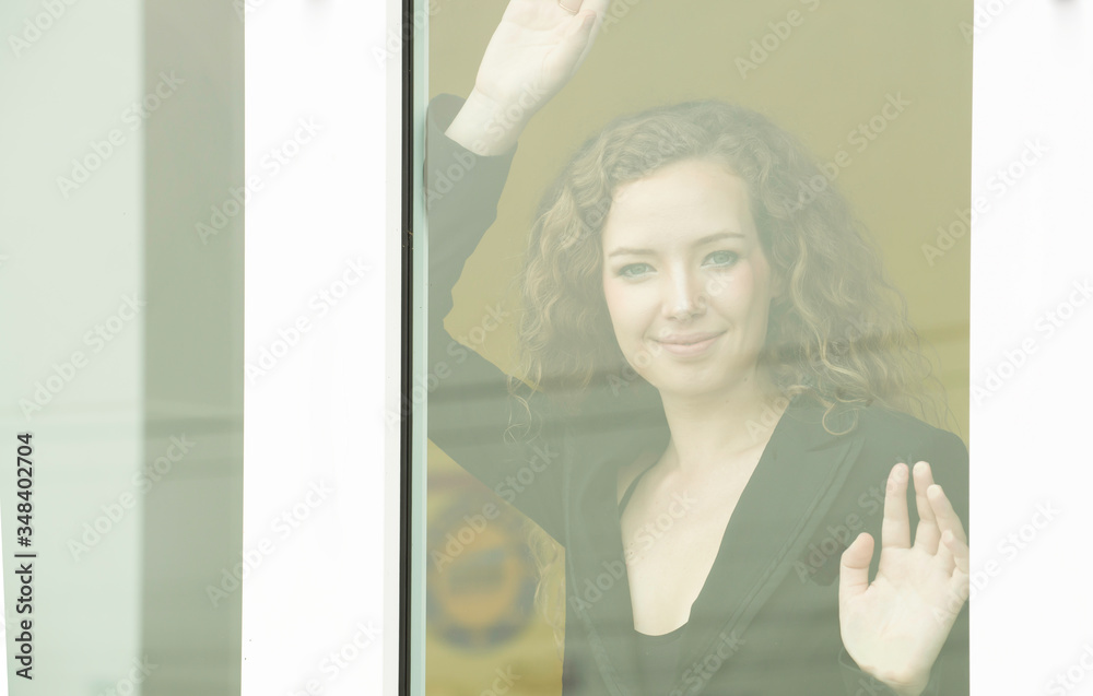 Business beautiful woman behind their glass window of home say hello to ...
