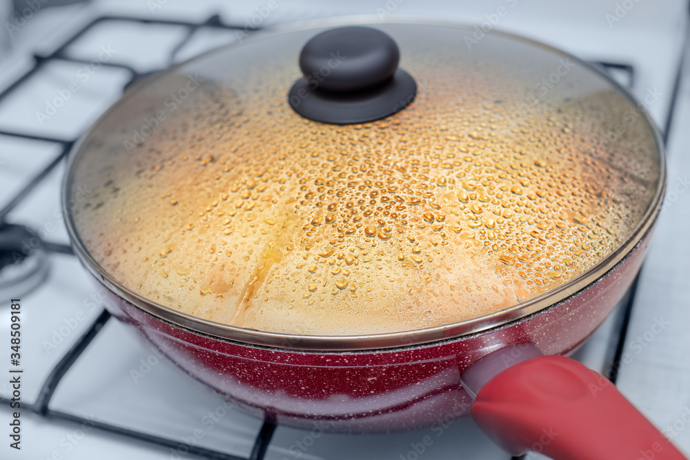 Water droplets formed under the lid of the pan while cooking vegetable ...