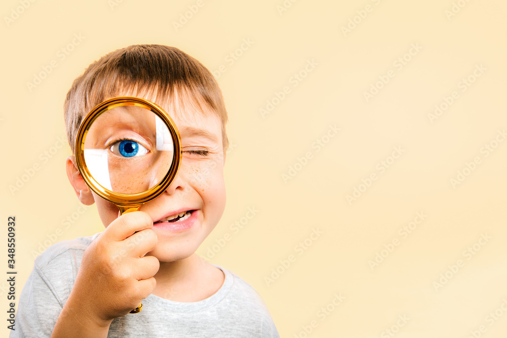 Child see through magnifying glass on the color yellow backgrounds. Big ...