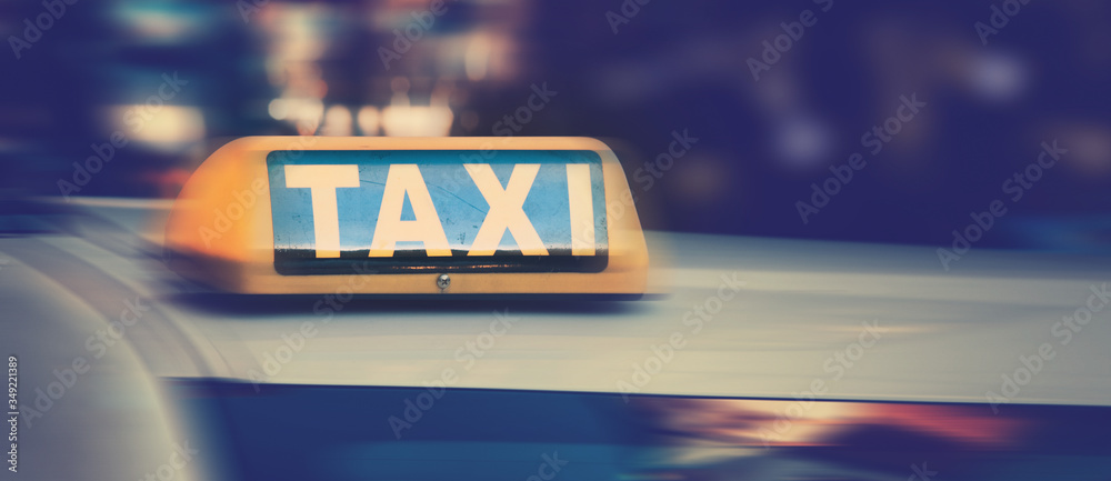 Taxi sign on top of taxi cab at night. City bokeh lights in the ...
